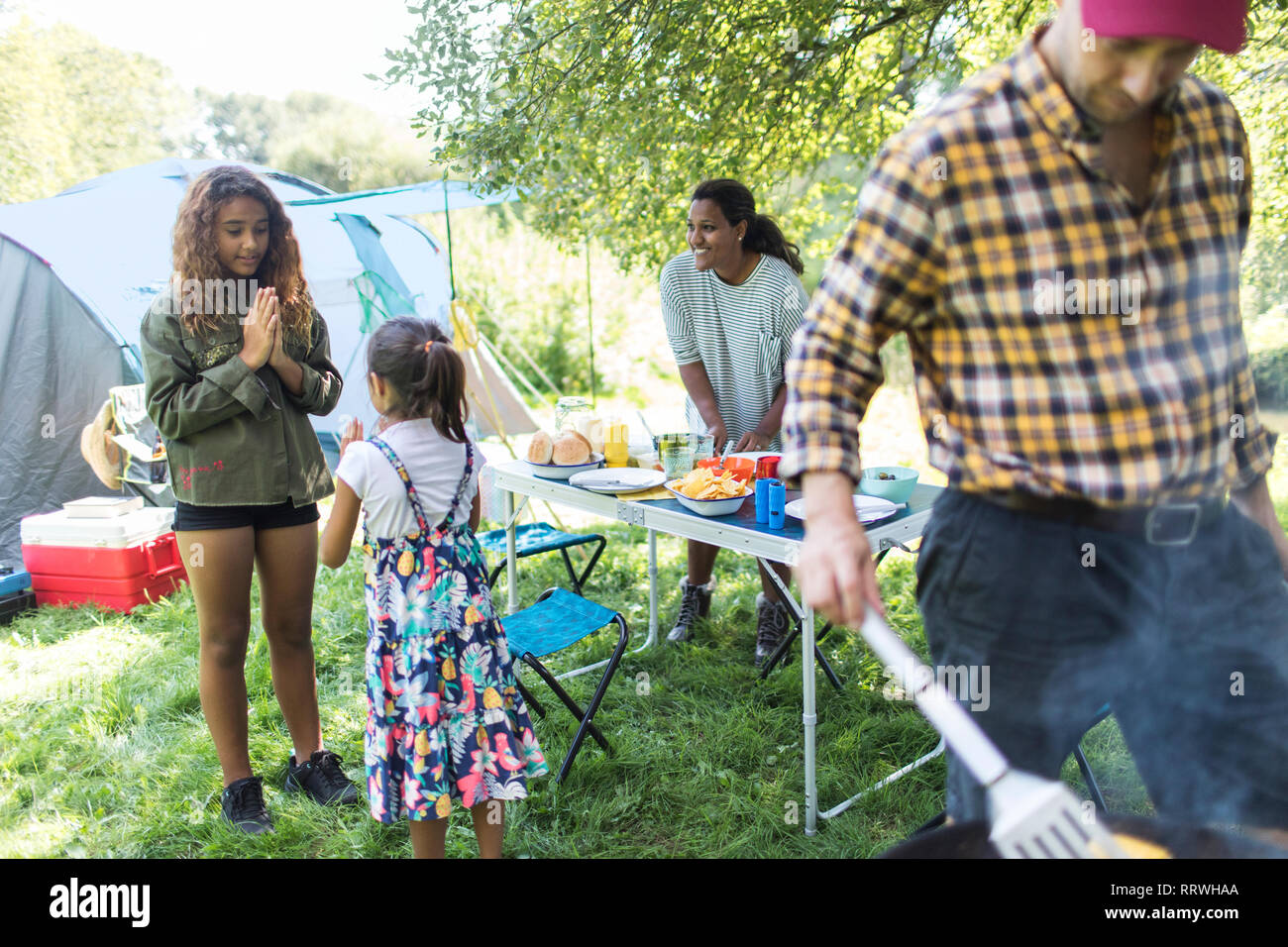 Family preparing barbecue lunch at campsite Stock Photo - Alamy