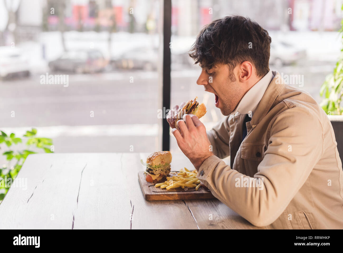 Man eating hamburger fries hi-res stock photography and images - Alamy
