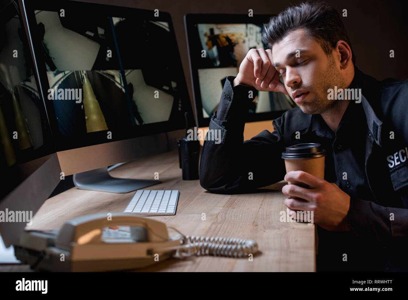 guard holding paper cup and sleeping in uniform at workplace Stock ...