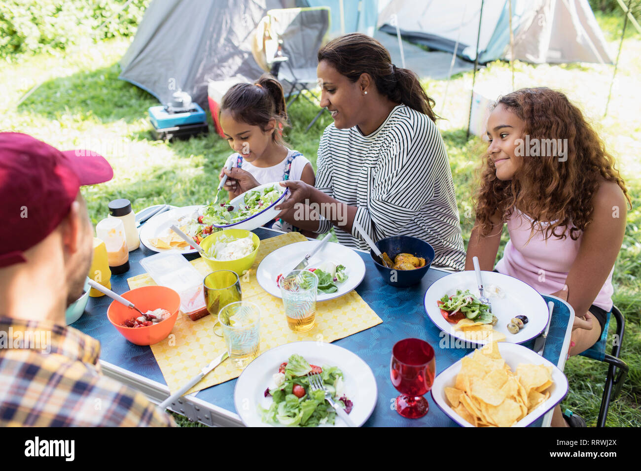 Family enjoying lunch at campsite table Stock Photo - Alamy