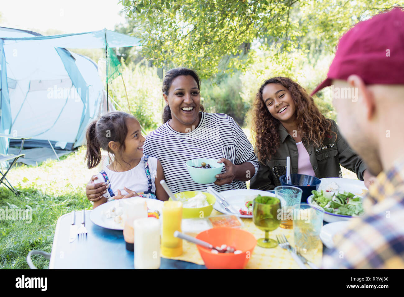 Happy family enjoying lunch at campsite table Stock Photo - Alamy