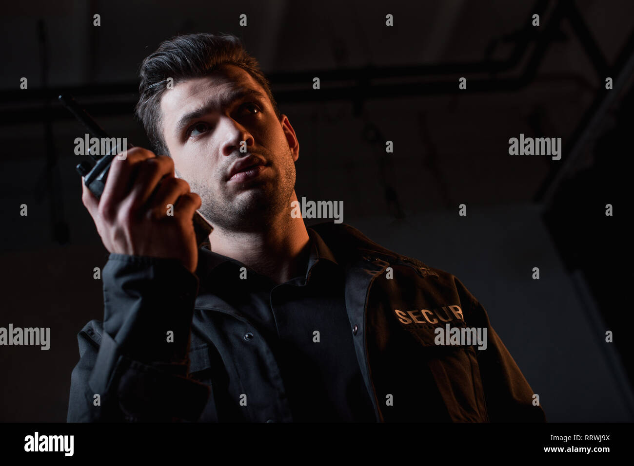 guard in uniform using walkie-talkie and looking away Stock Photo - Alamy