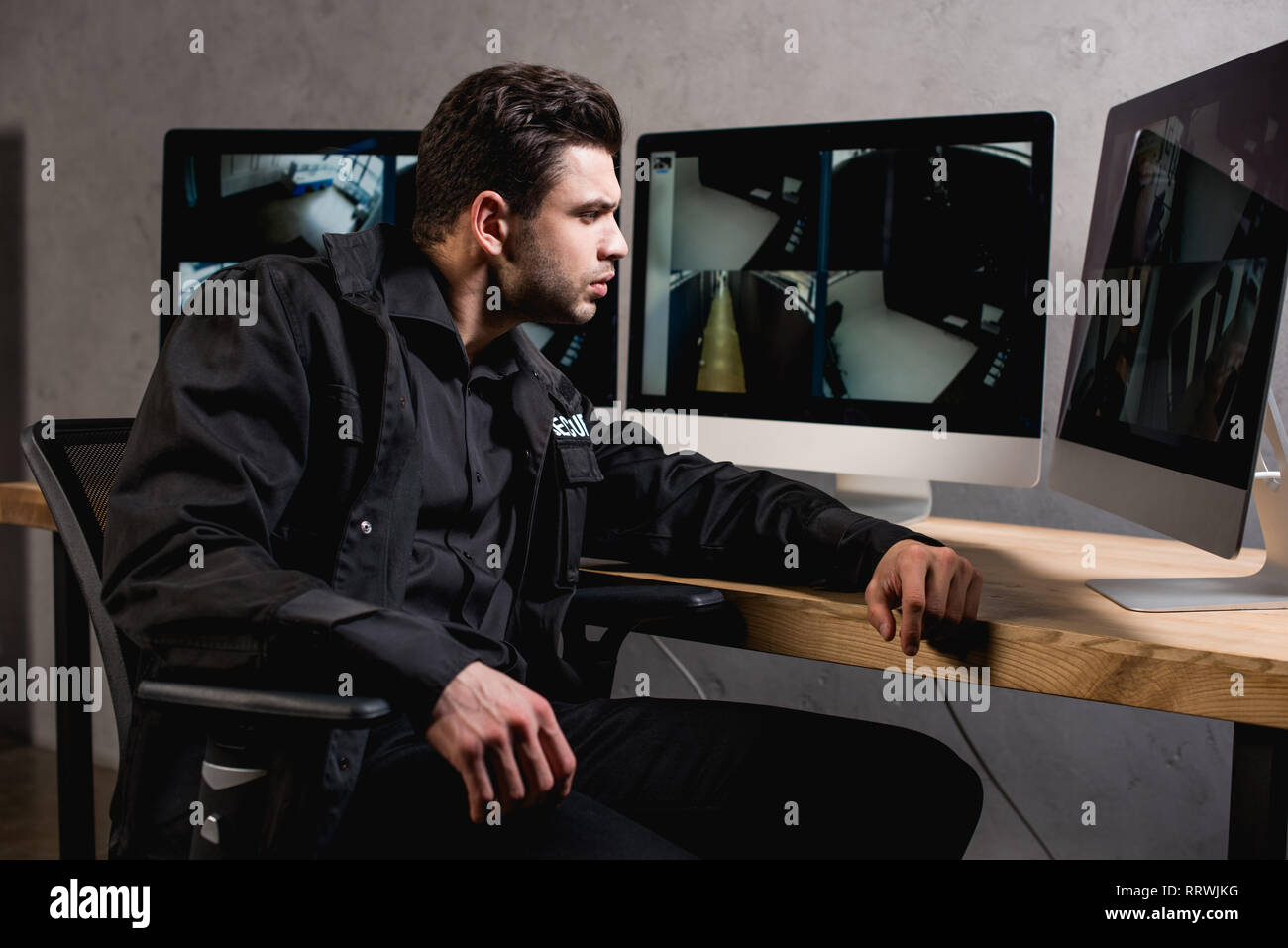 focused guard in uniform looking at computer monitor at workspace Stock ...