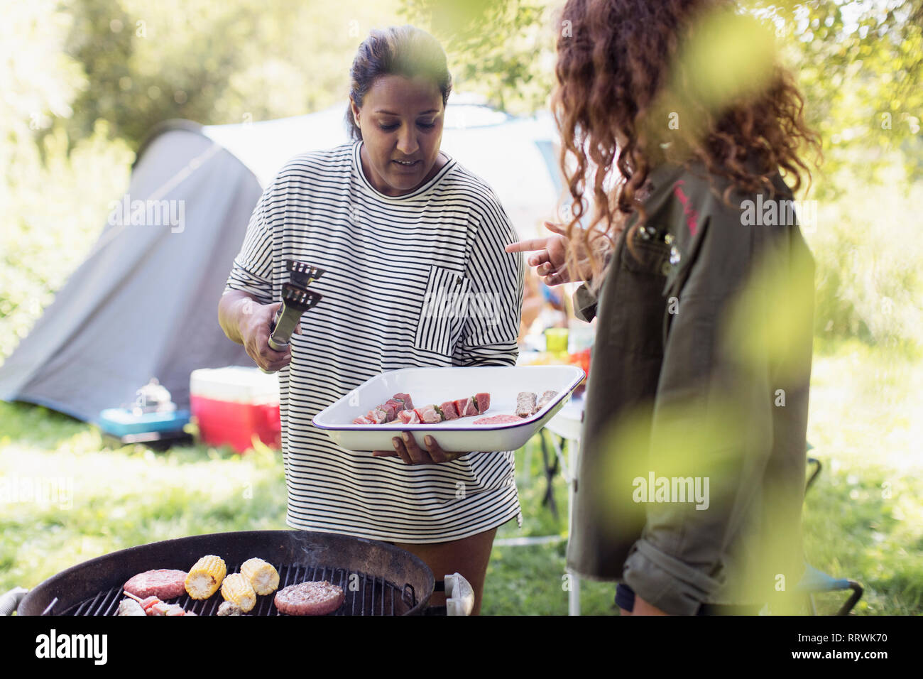Mother and daughter barbecuing at campsite Stock Photo - Alamy