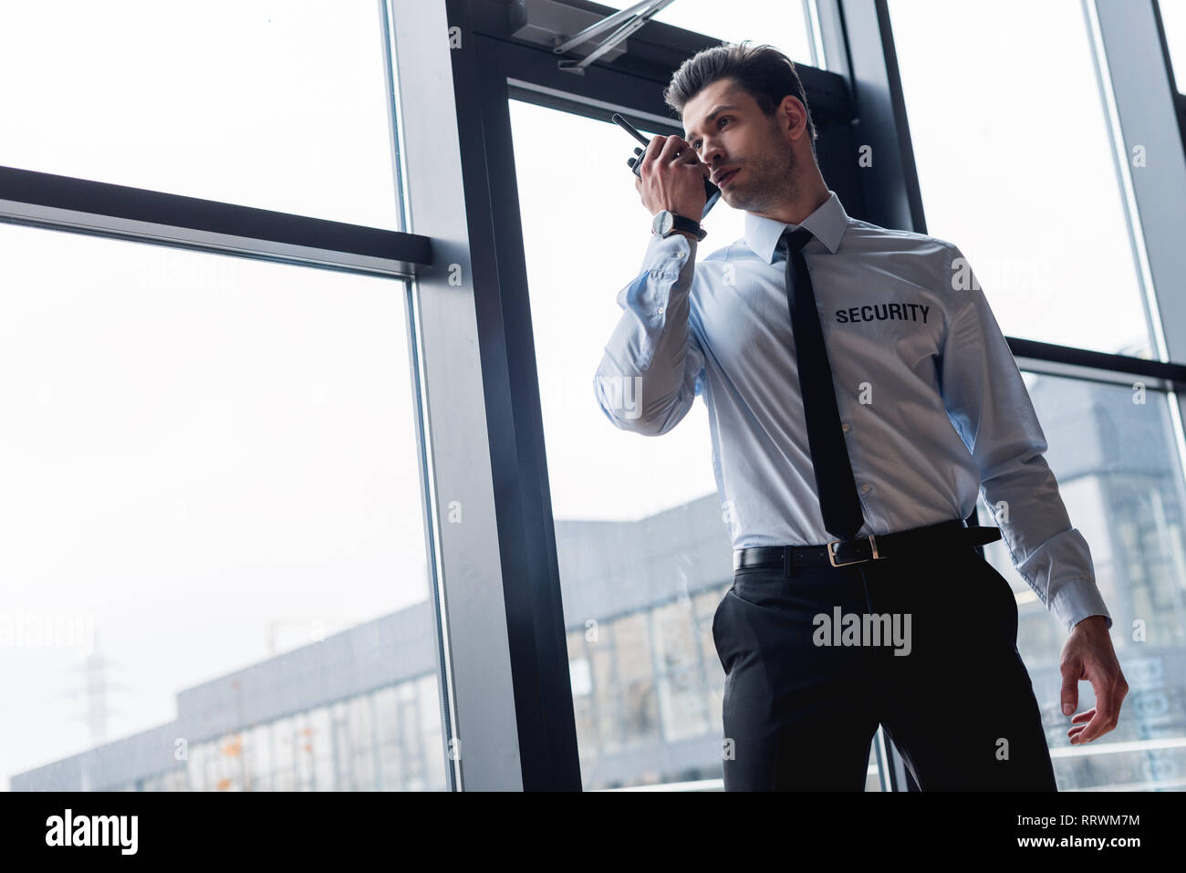 handsome guard in suit talking on walkie-talkie Stock Photo - Alamy