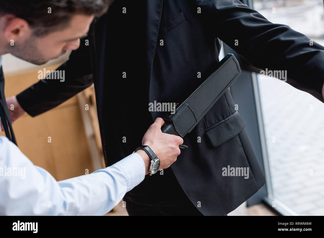 cropped view of guard using metal detector Stock Photo - Alamy