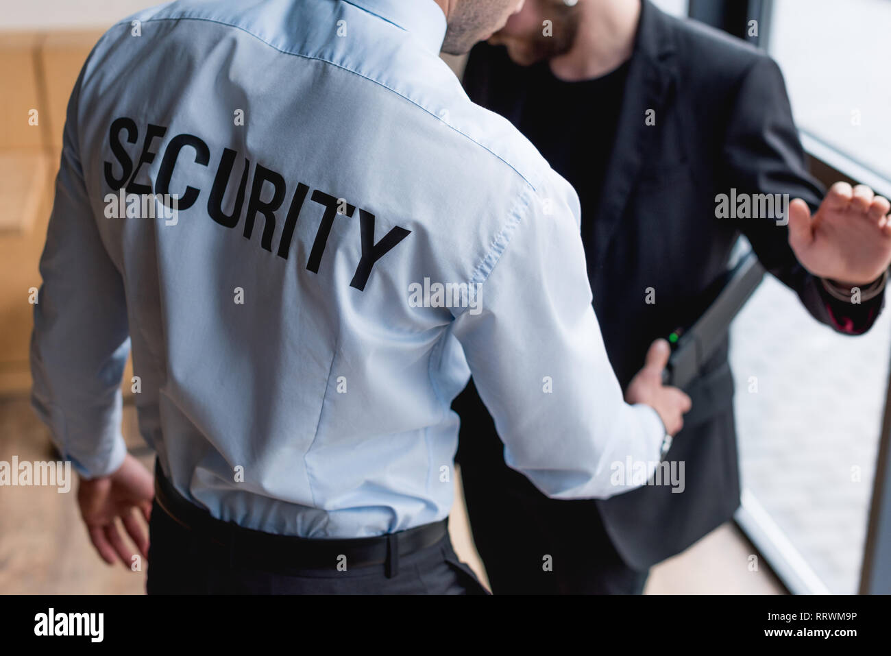 partial view of guard using metal detector Stock Photo - Alamy