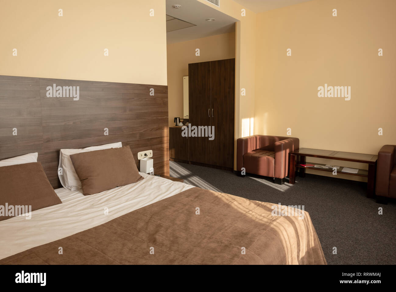 hotel bedroom interior with bed in beige color Stock Photo - Alamy