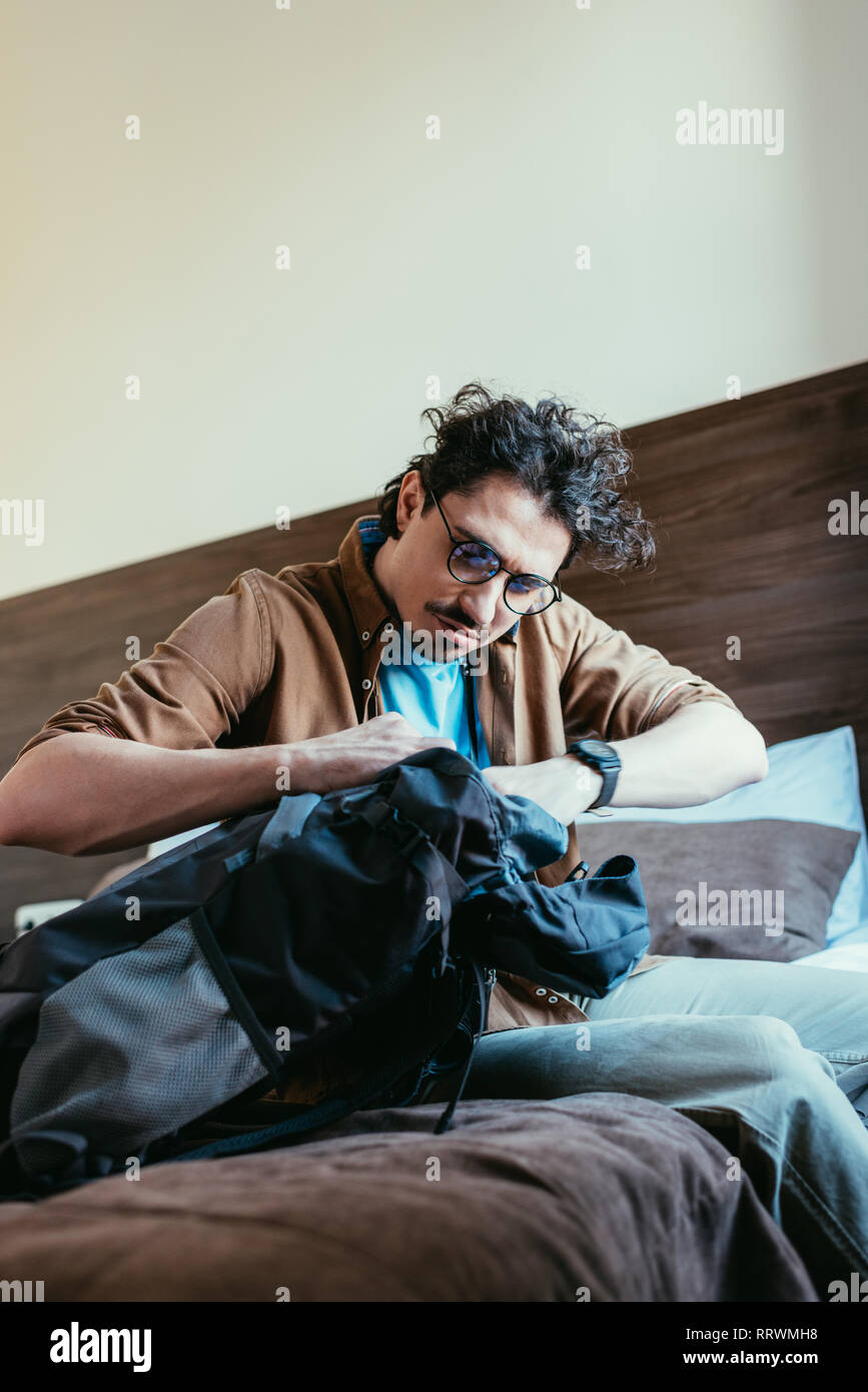 man in eyeglasses taking something from backpack in hotel room Stock ...