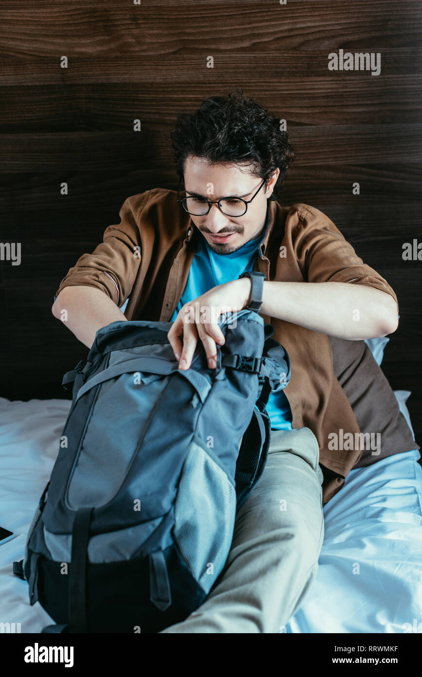 male traveler taking something from backpack in hotel room Stock Photo ...