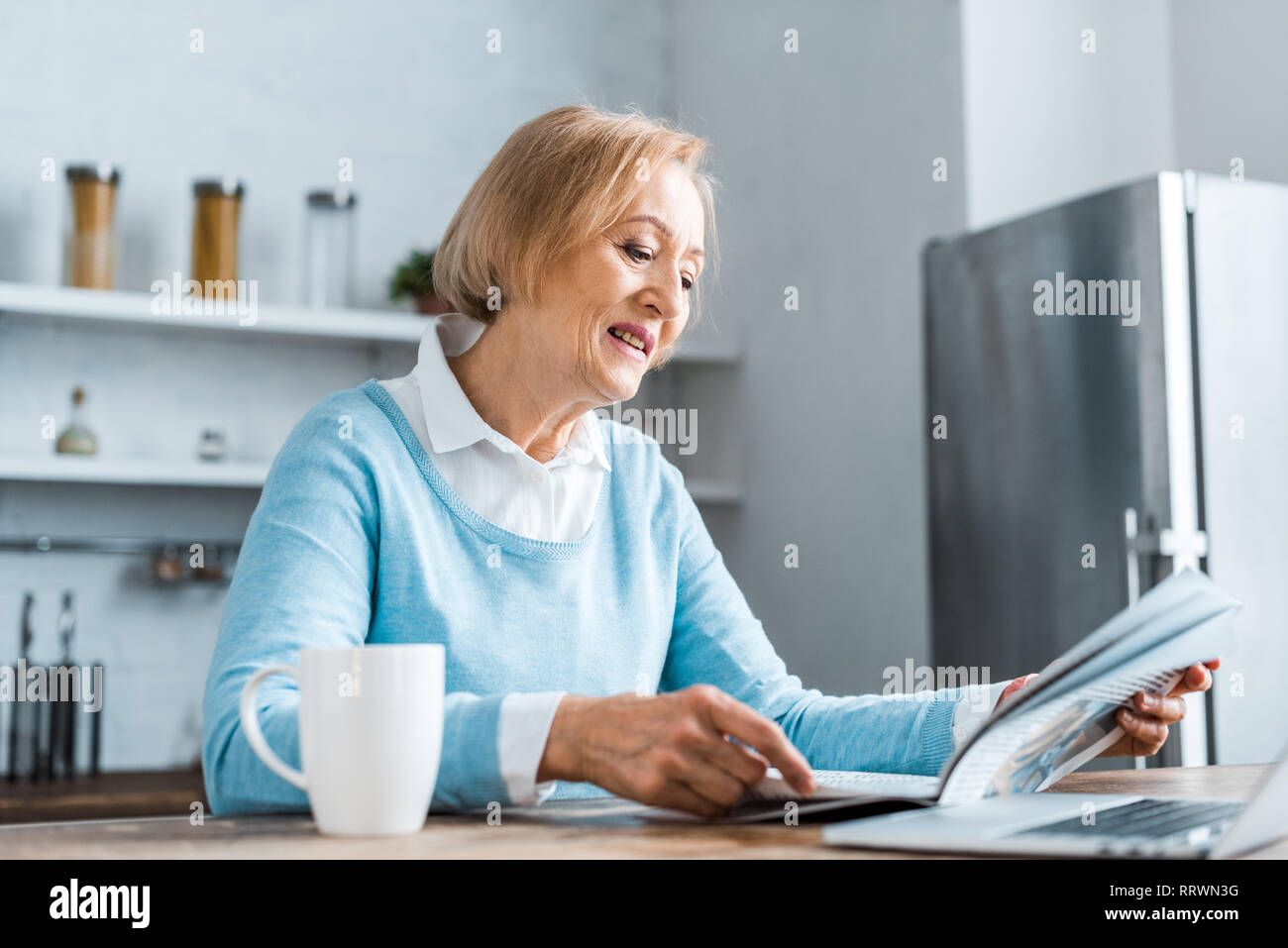 Elderly woman sitting reading newspaper hi-res stock photography and ...