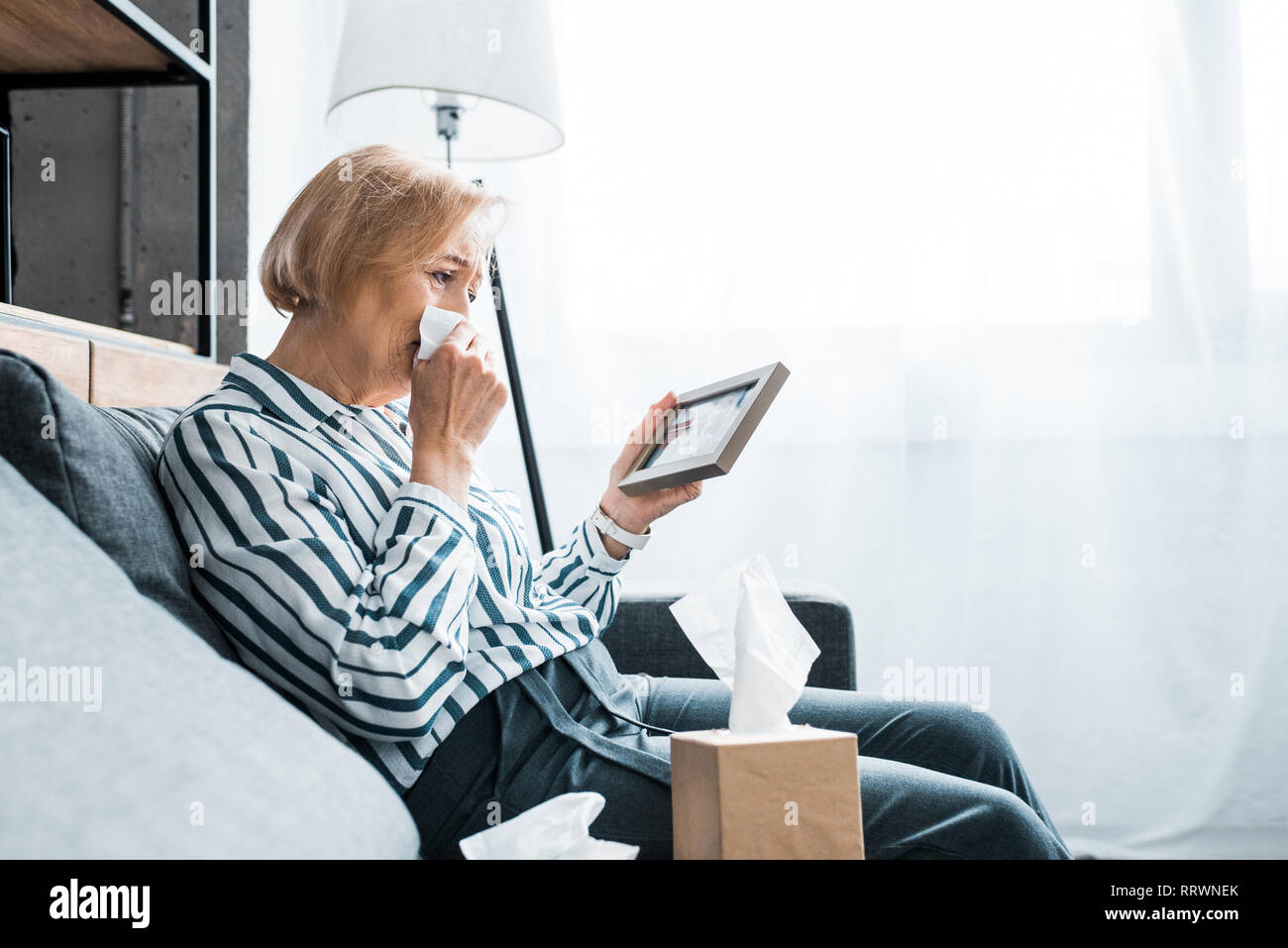 depressed senior woman crying and wiping face from tears with tissue ...