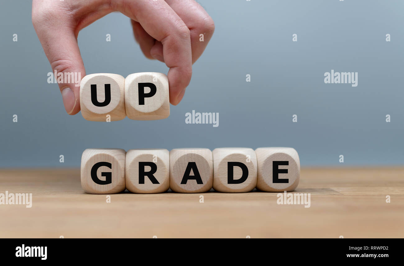 Dice built the word "UPGRADE" while a hand lifts the letters "UP Stock ...