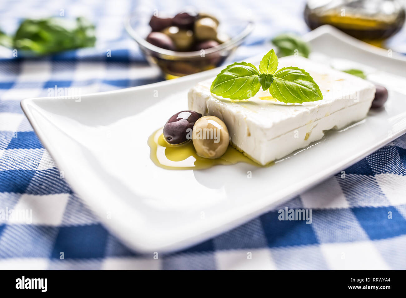 Greek cheese feta with olive oil olives and basil leaves Stock Photo ...