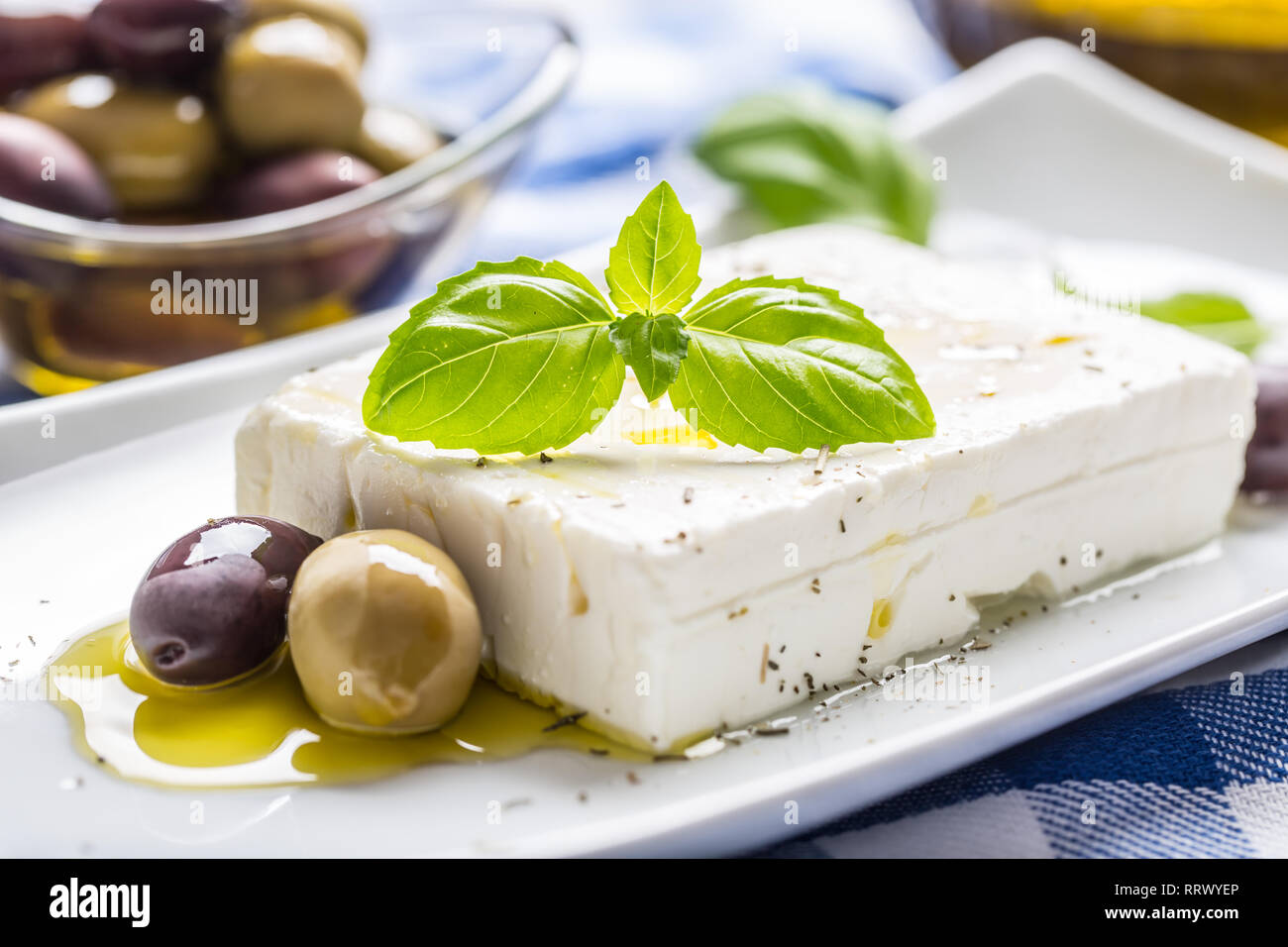 Greek cheese feta with olive oil olives and basil leaves Stock Photo ...