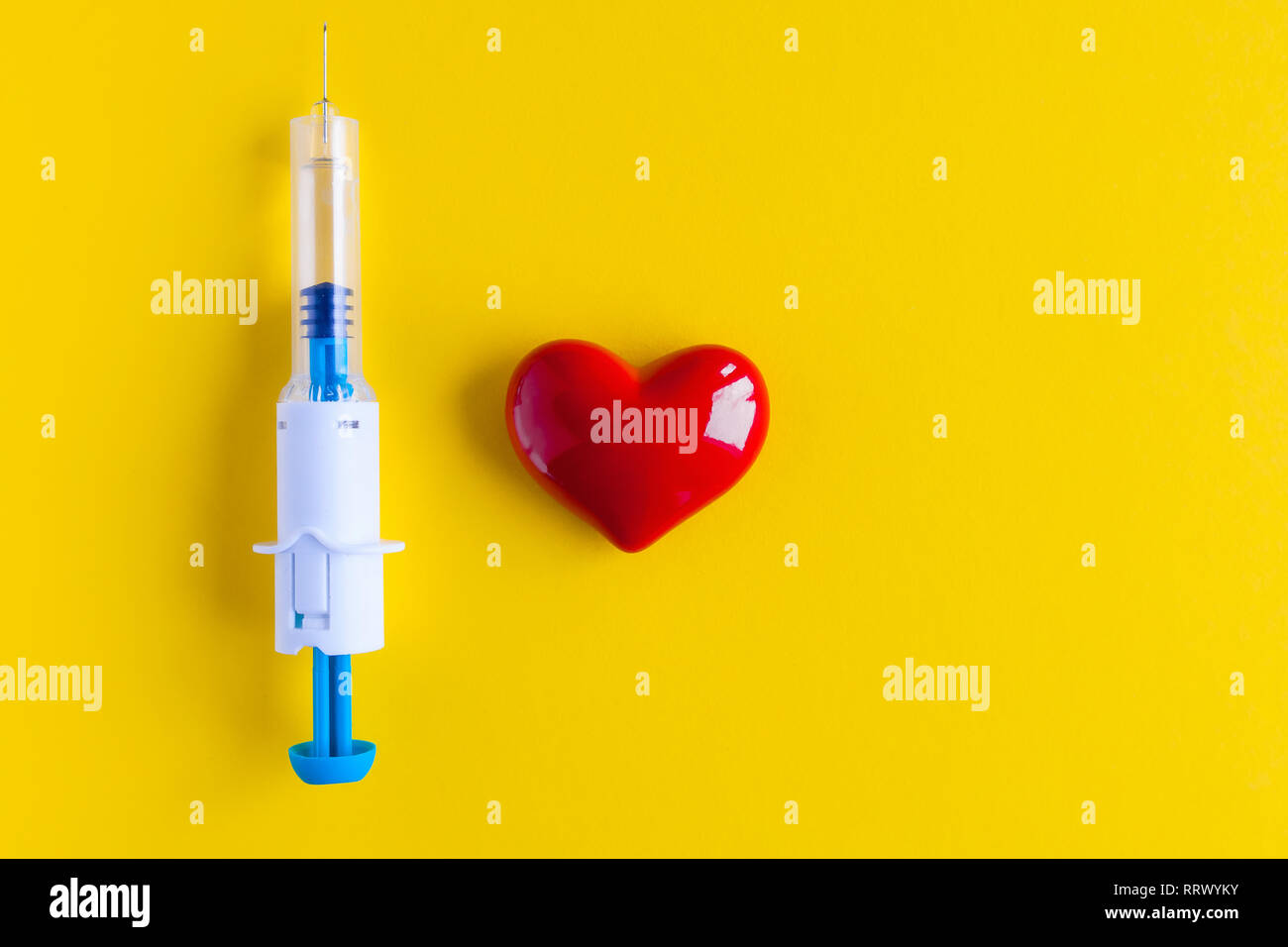 Volumetric heart shape with a syringe on a yellow background. Use for ...