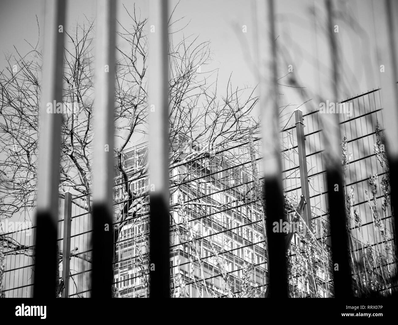 Abstract view of business building seen through security fences - black ...