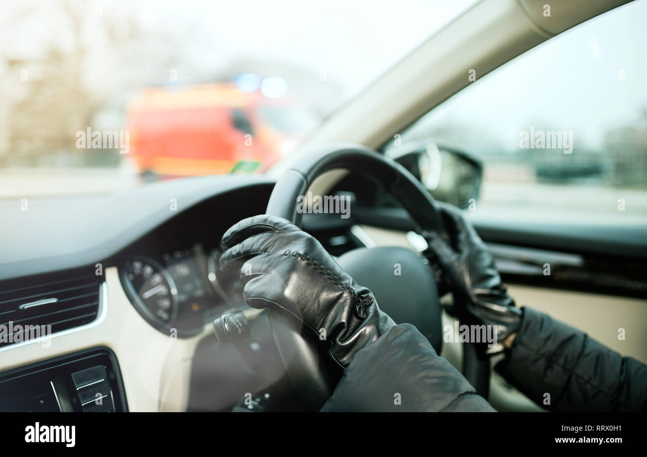 Side view of woman driving car wearing leather gloves - focus on the ...