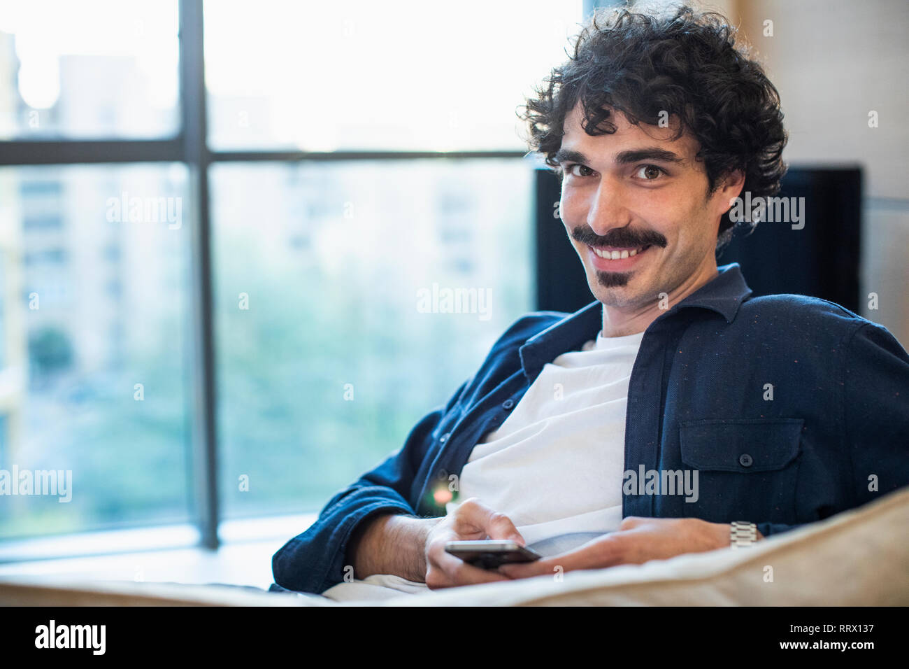 Man using mobile sitting on sofa hi-res stock photography and images ...
