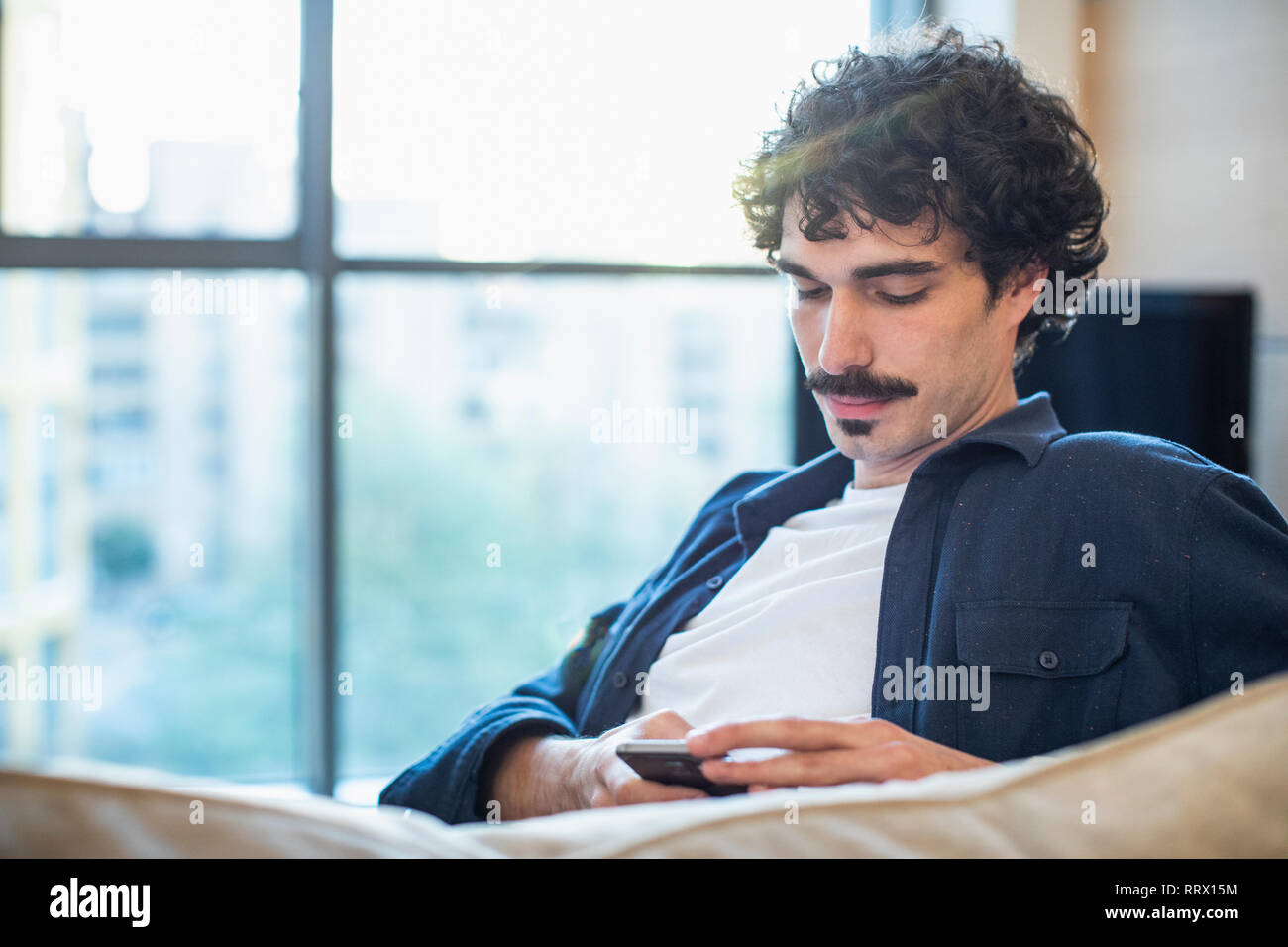 Man using mobile sitting on sofa hi-res stock photography and images ...