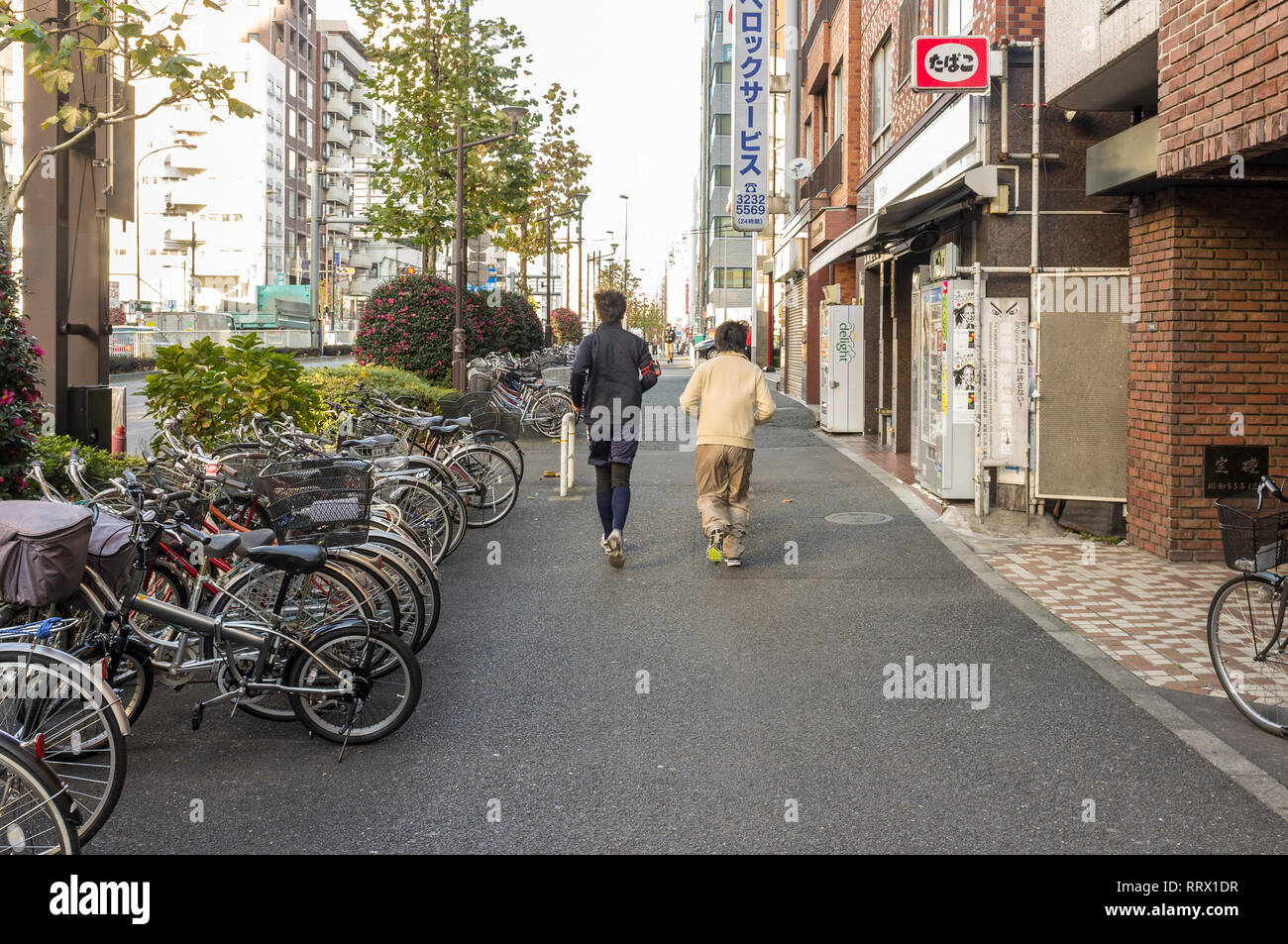 Two men jogging on a pavement in Tokyo, Japan Stock Photo - Alamy