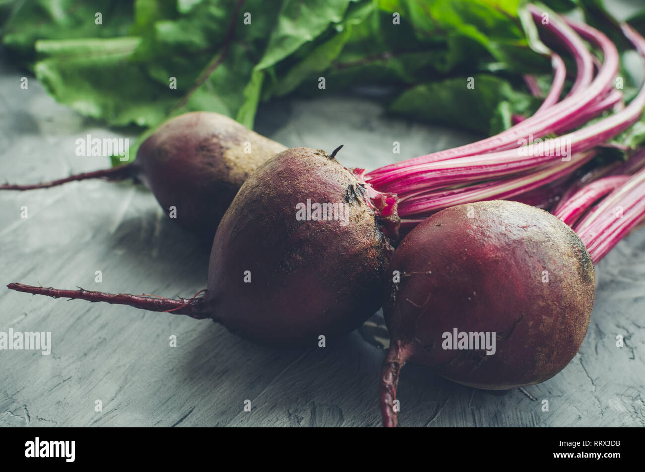 Pile of homegrown organic young beets with green leaves on the table ...