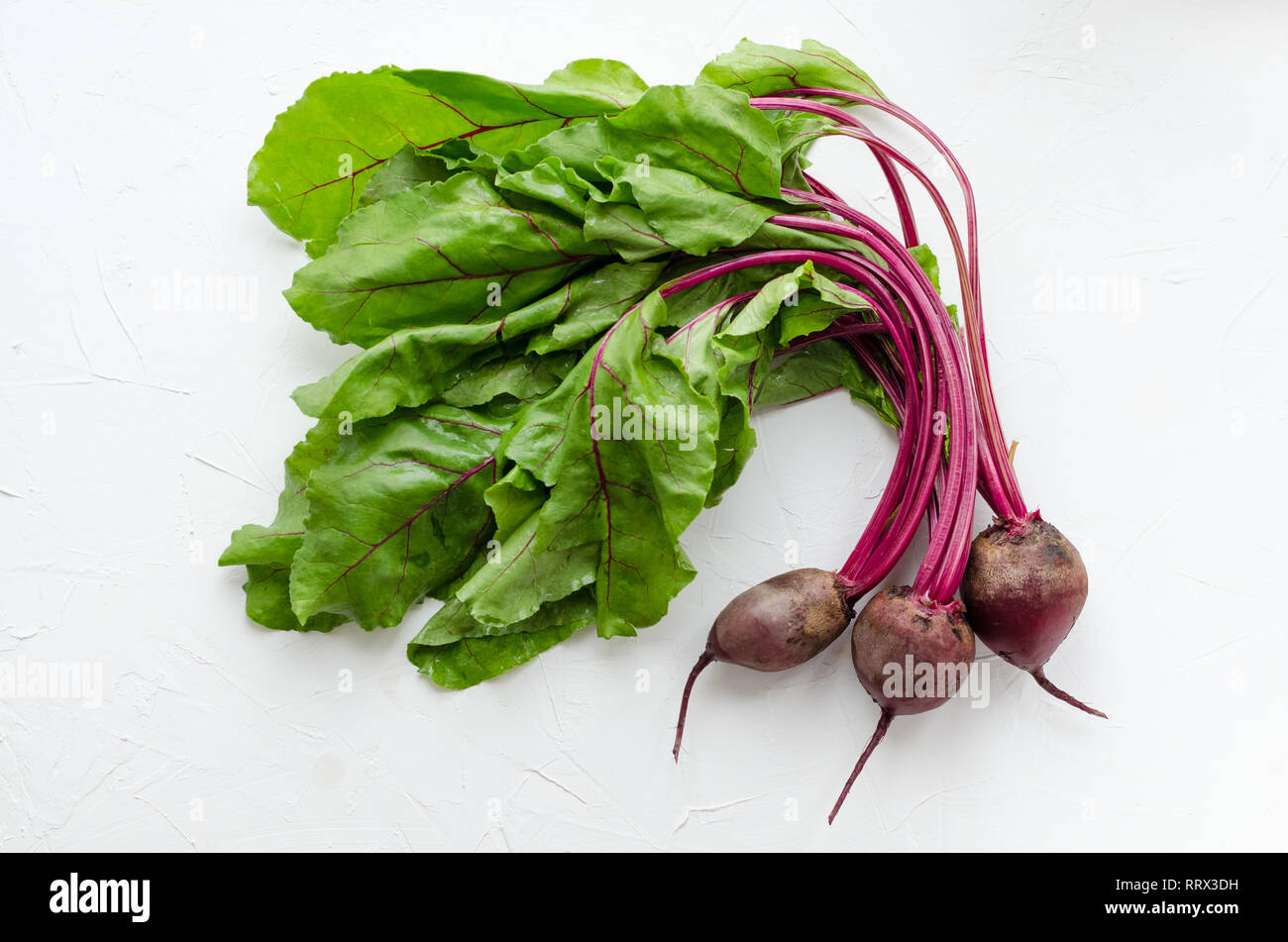 Bunch of homegrown organic young beets with green leaves on the table ...