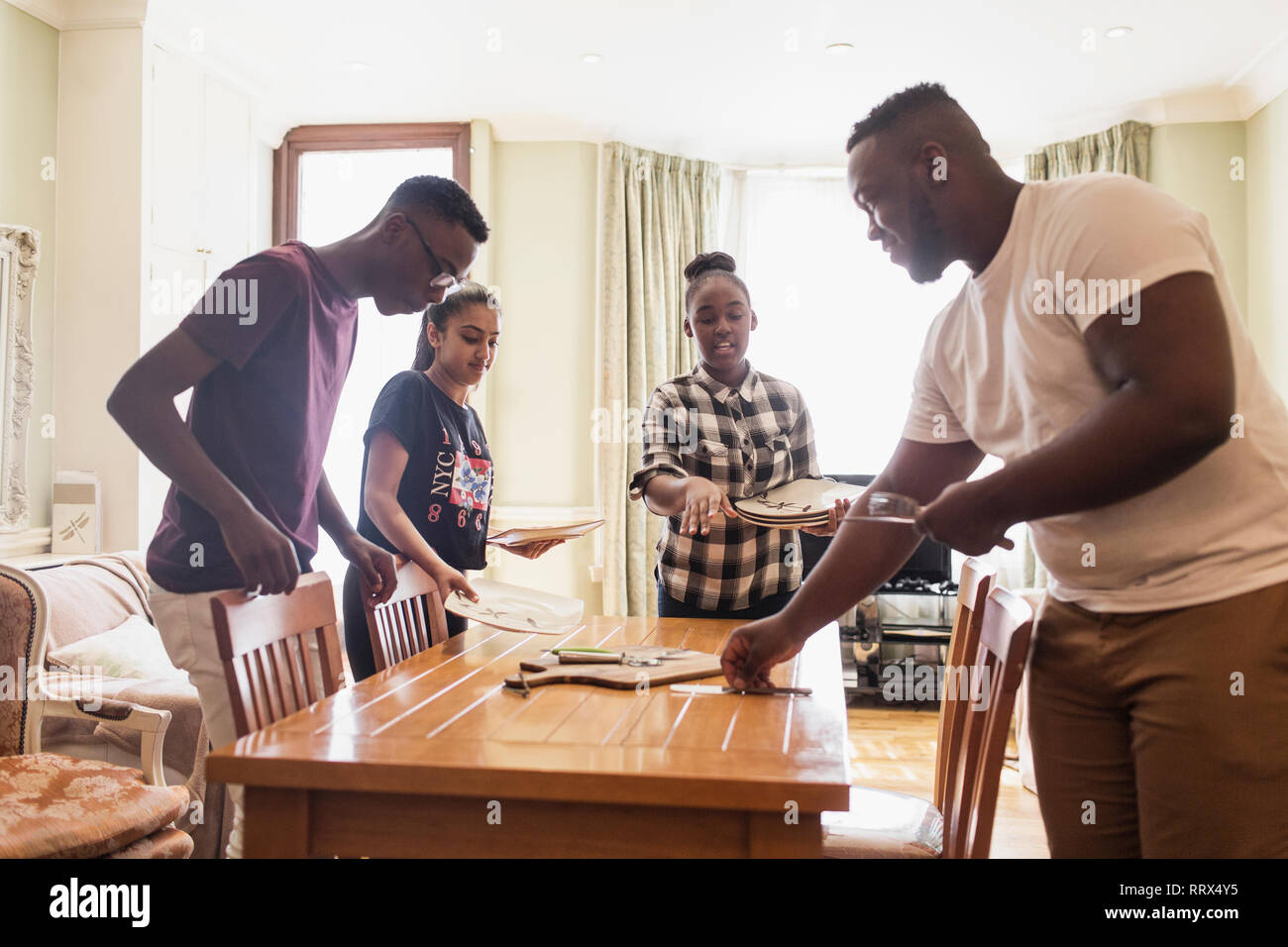 Teenage siblings setting the table Stock Photo - Alamy