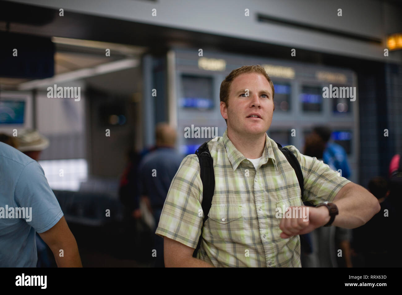 Man checking his watch inside an airport Stock Photo - Alamy