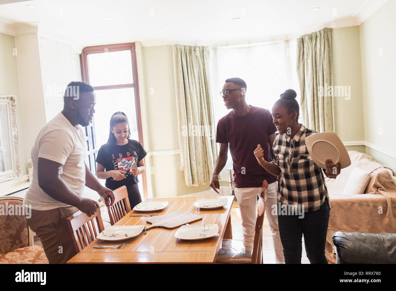 Teenage siblings setting dining room table Stock Photo - Alamy