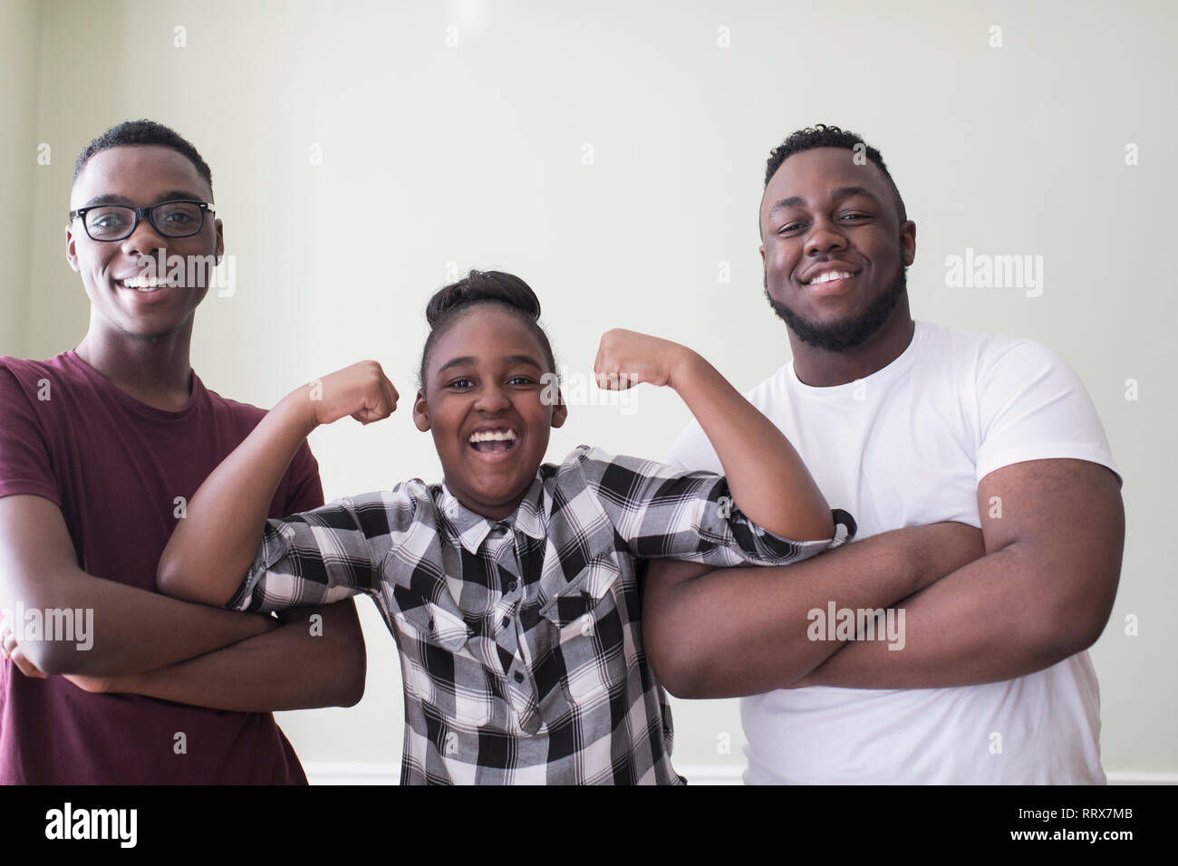 Portrait confident teenage brothers and sister flexing muscles Stock ...