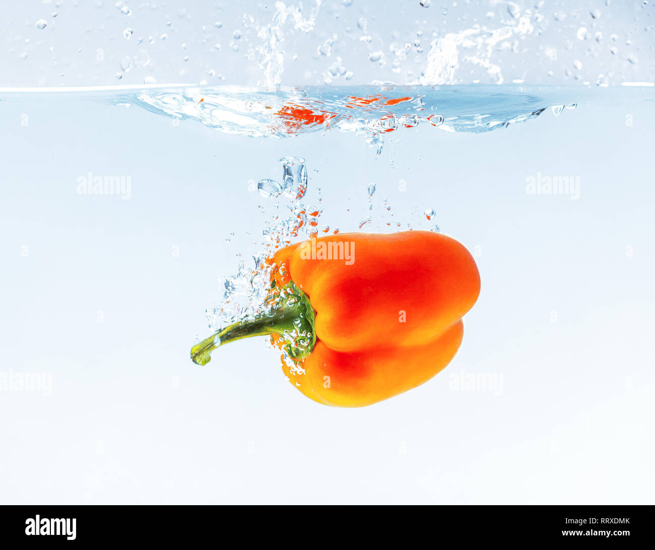 Colored orange paprika in water splashes on blue background Stock Photo ...