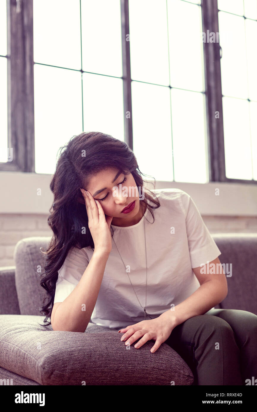 Beautiful tired woman sitting with closed eyes Stock Photo - Alamy