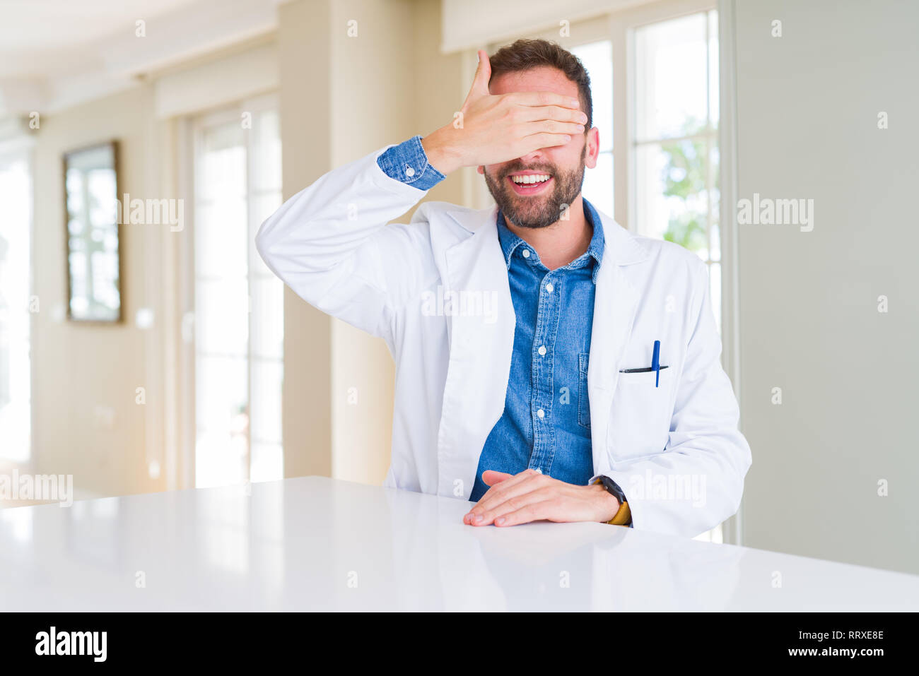 Handsome doctor man wearing medical coat at the clinic smiling and ...