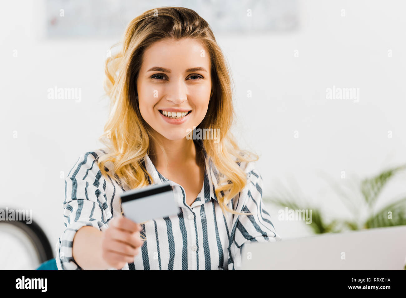 Laughing beautiful woman in striped shirt holding credit card Stock ...