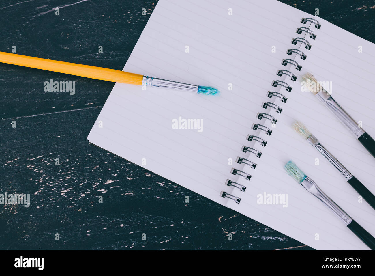 desk with notepads and watercolour brushes with empty pages and ...