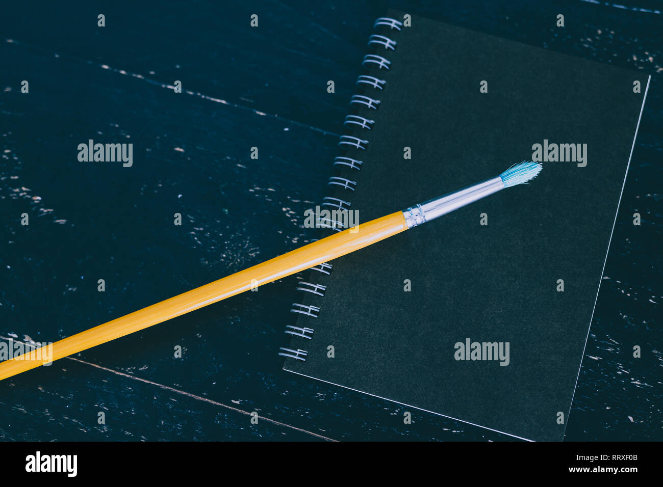 black desk with black notepad and watercolour brushes, concept of ...
