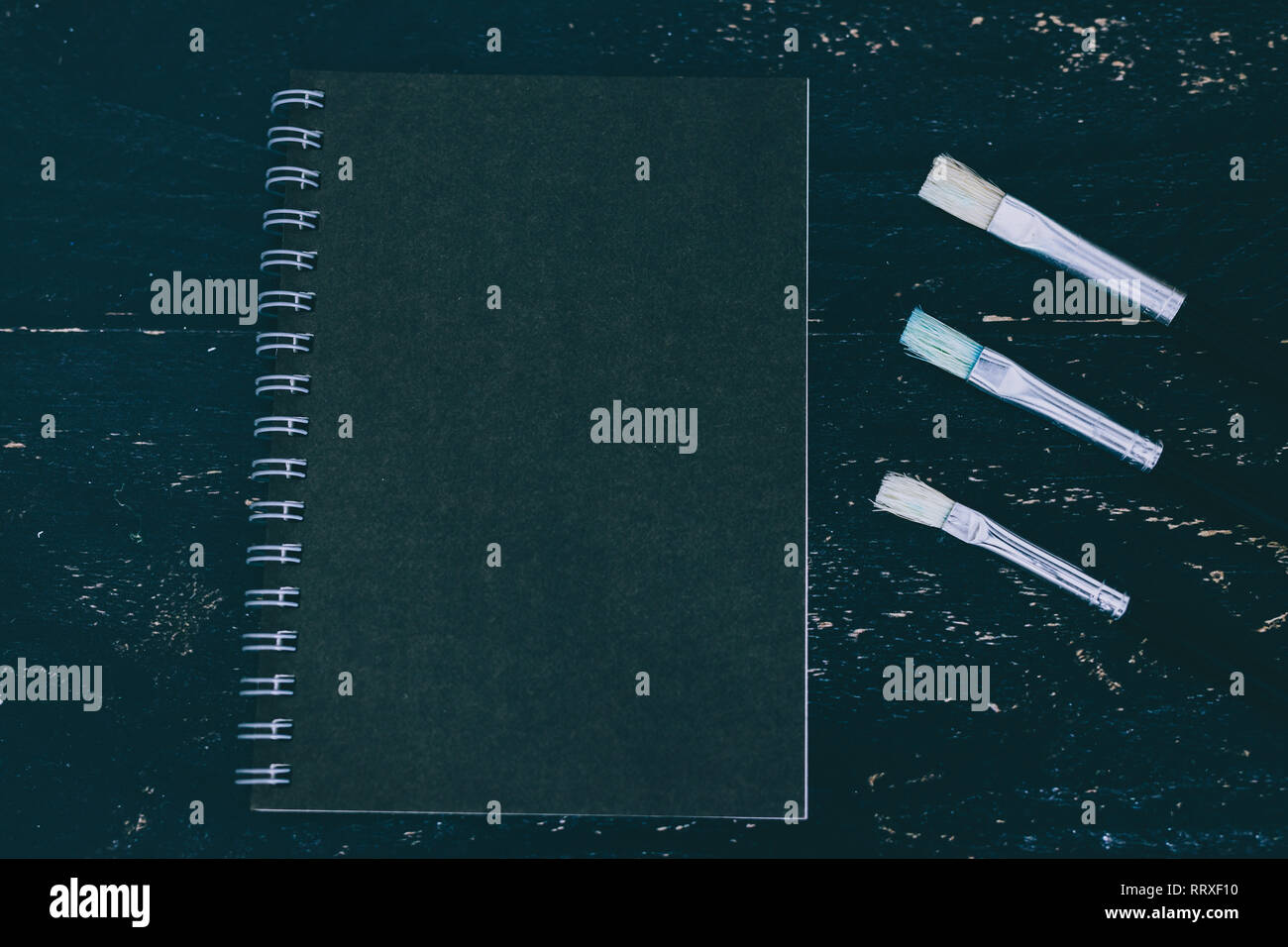 black desk with black notepad and watercolour brushes, concept of ...