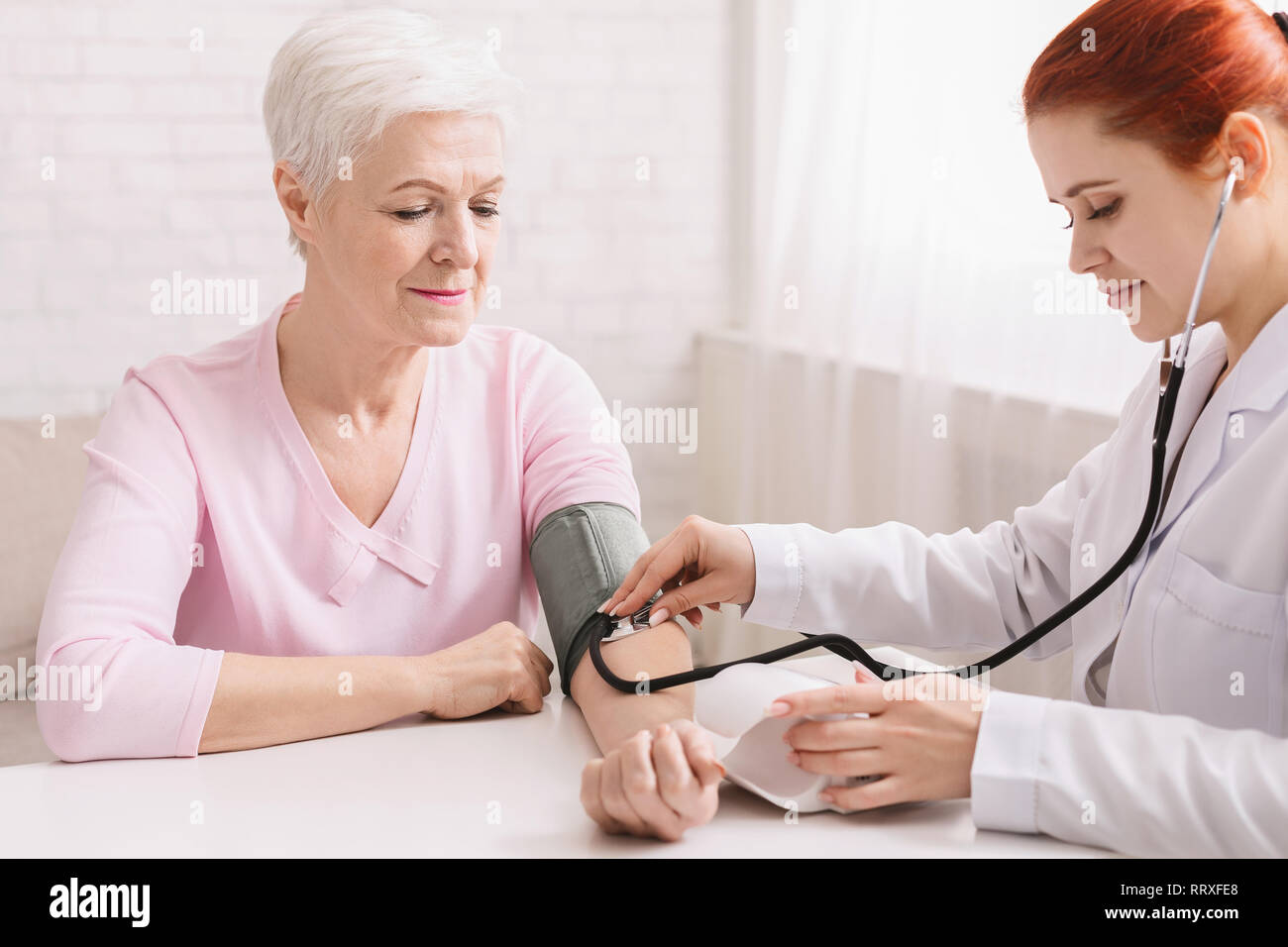 Doctor checking blood pressure of senior patient Stock Photo - Alamy