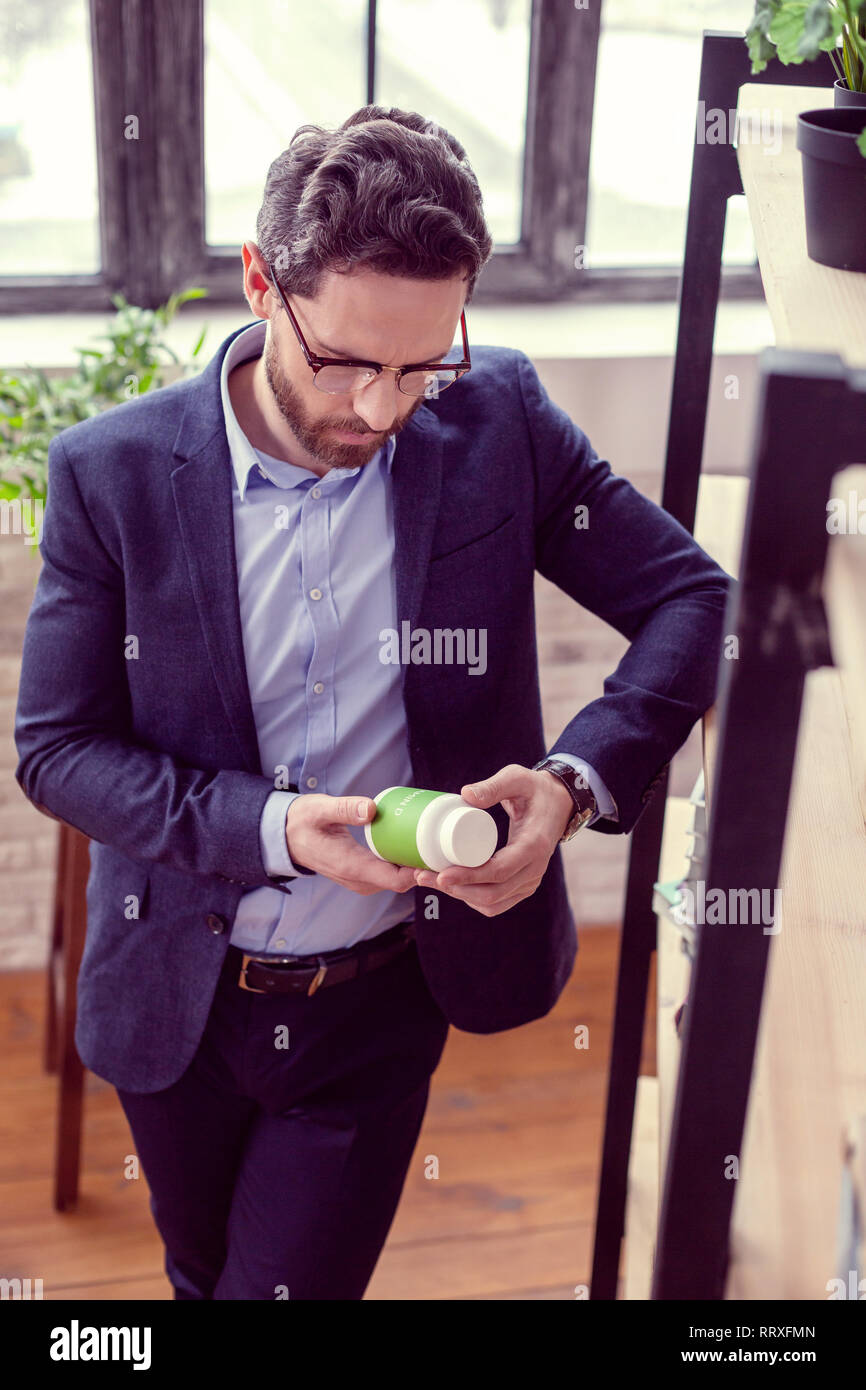 Intelligent handsome man standing with a bottle Stock Photo - Alamy