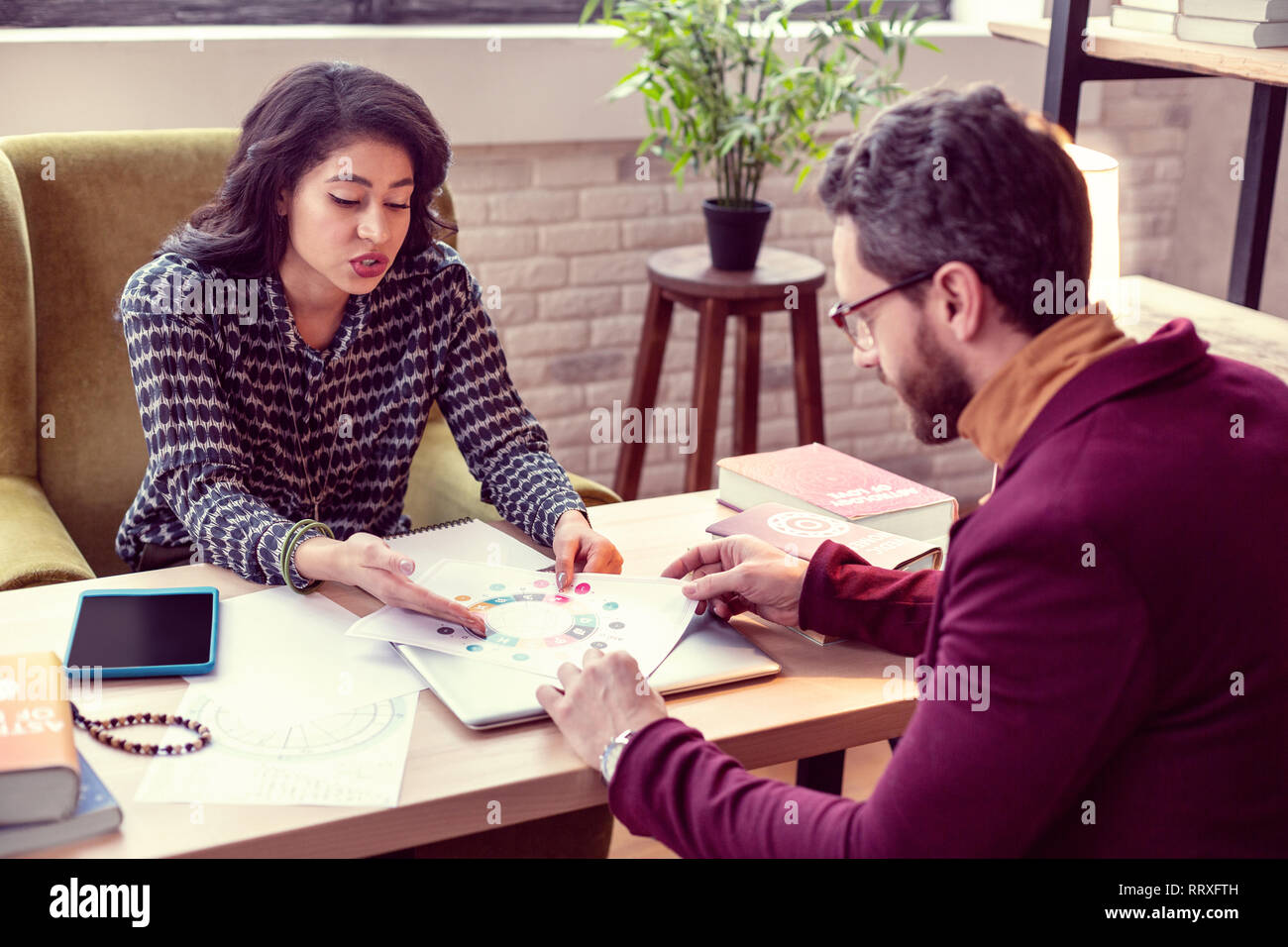 Professional female astrologist talking to her client Stock Photo - Alamy