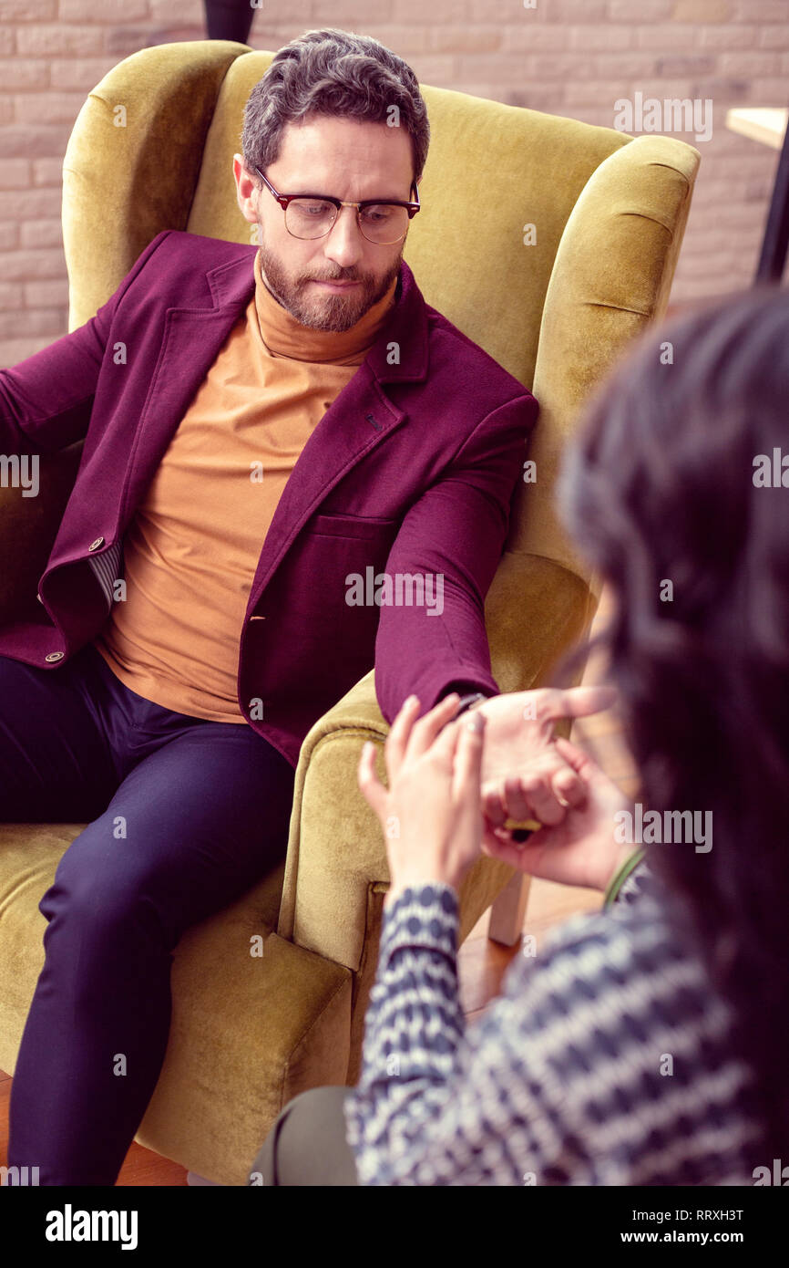 Pleasant nice young man giving his hand Stock Photo - Alamy