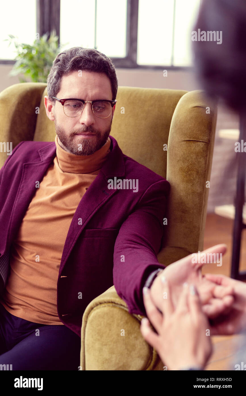 Nice serious smart man looking at his hand Stock Photo - Alamy