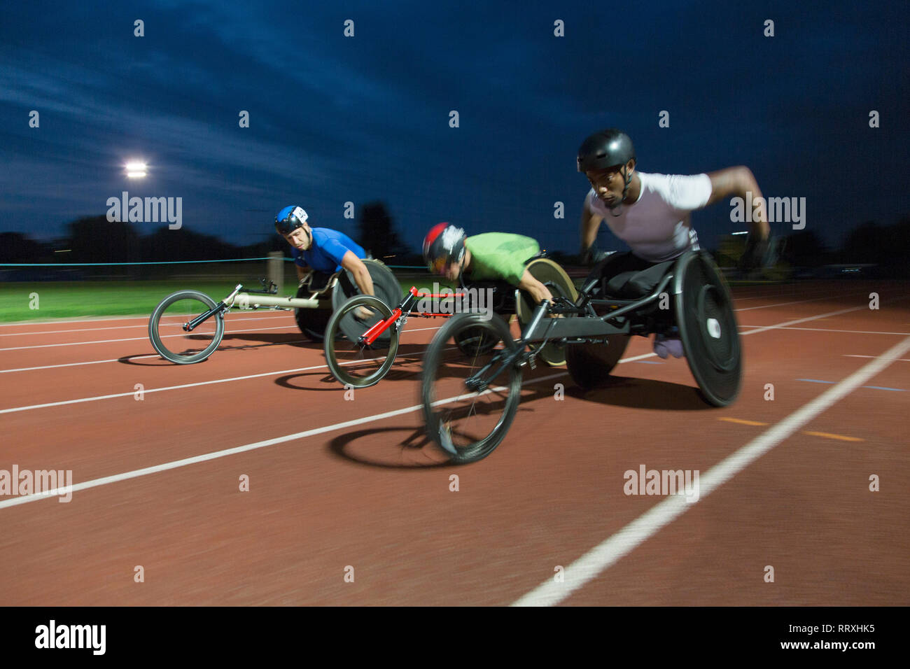 Paraplegic athletes racing along sports track in wheelchair race in ...