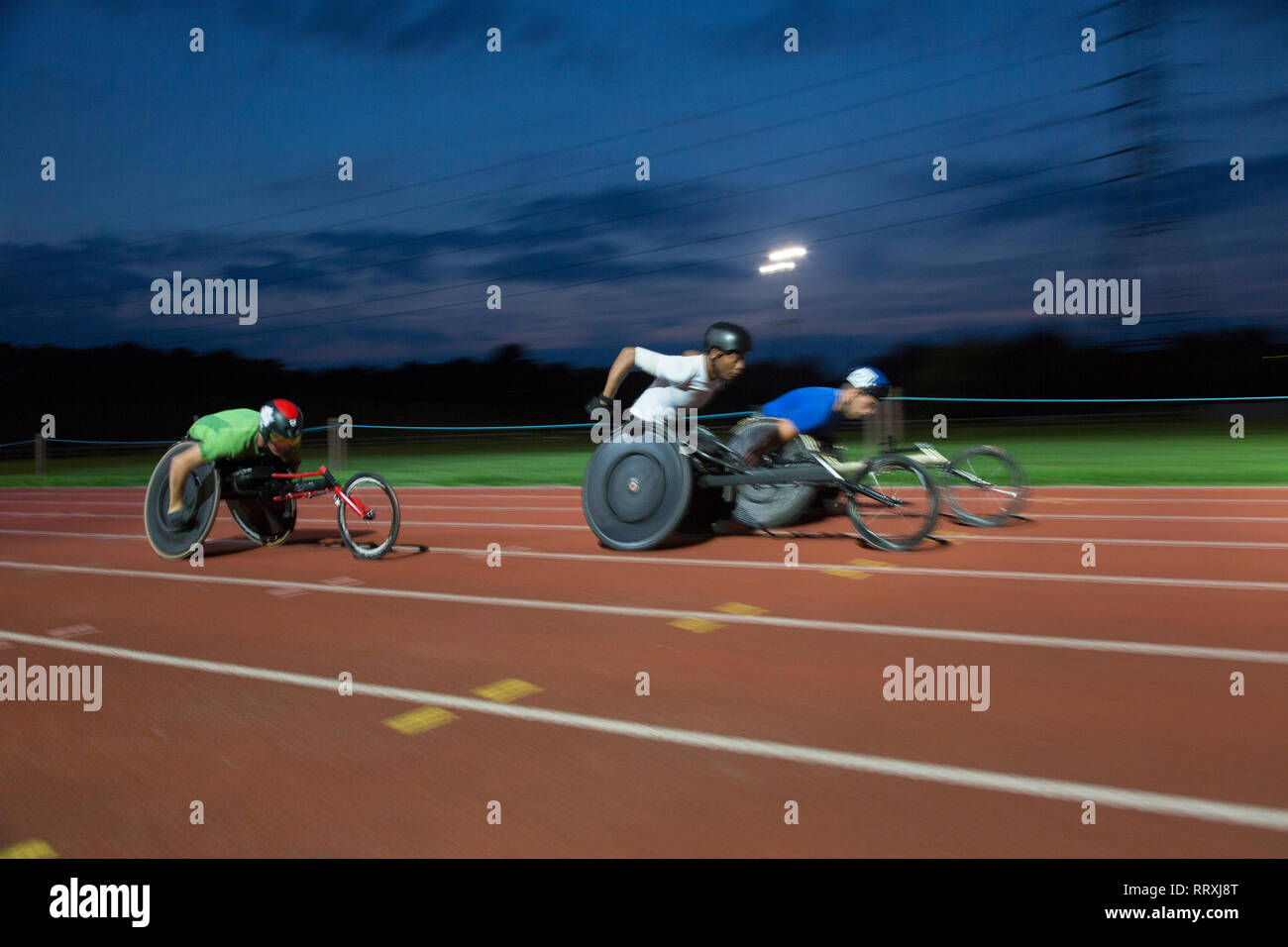 Paraplegic athletes speeding along sports track in wheelchair race at ...