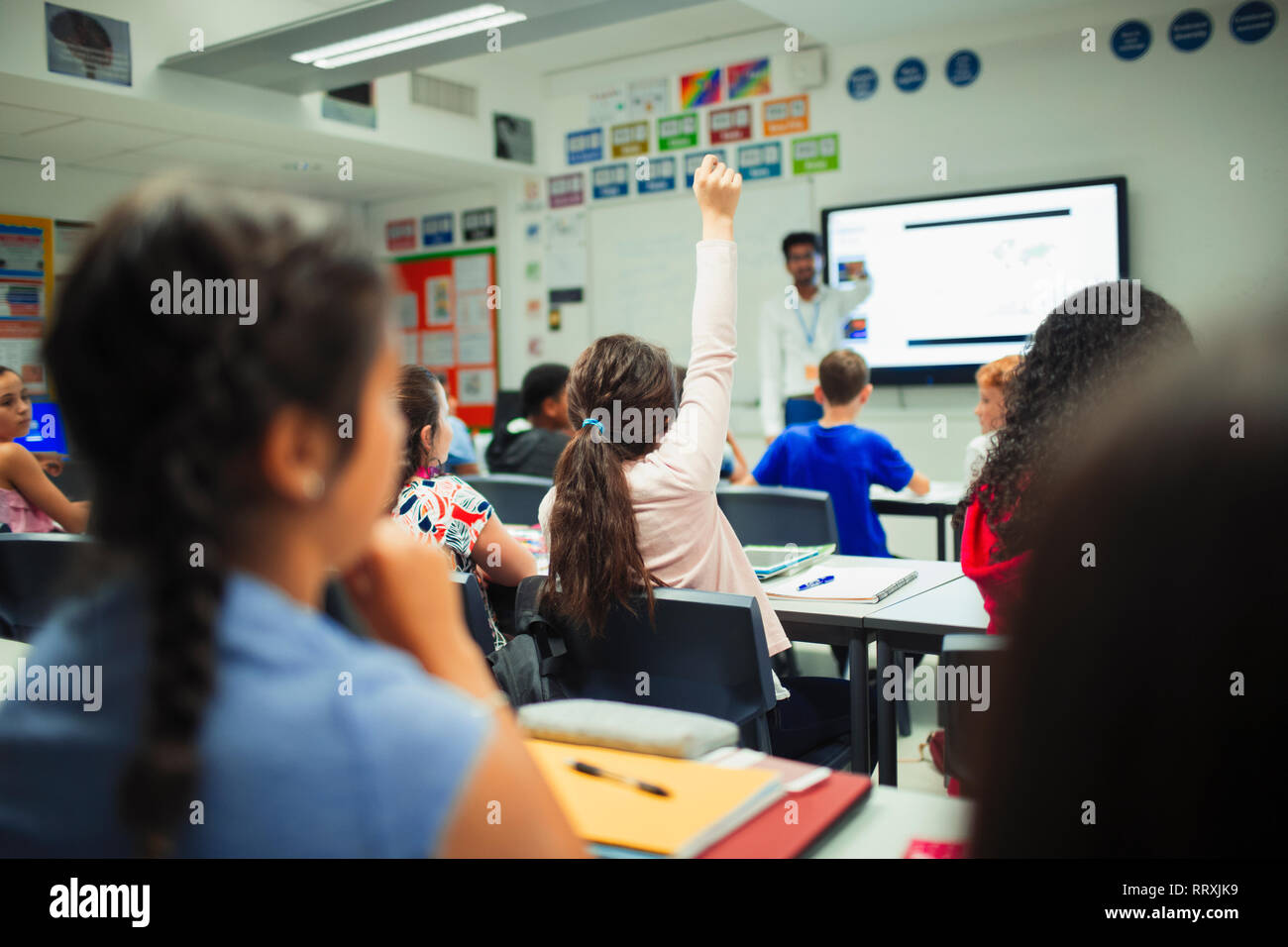 Junior high school student raising hand, asking a question during ...