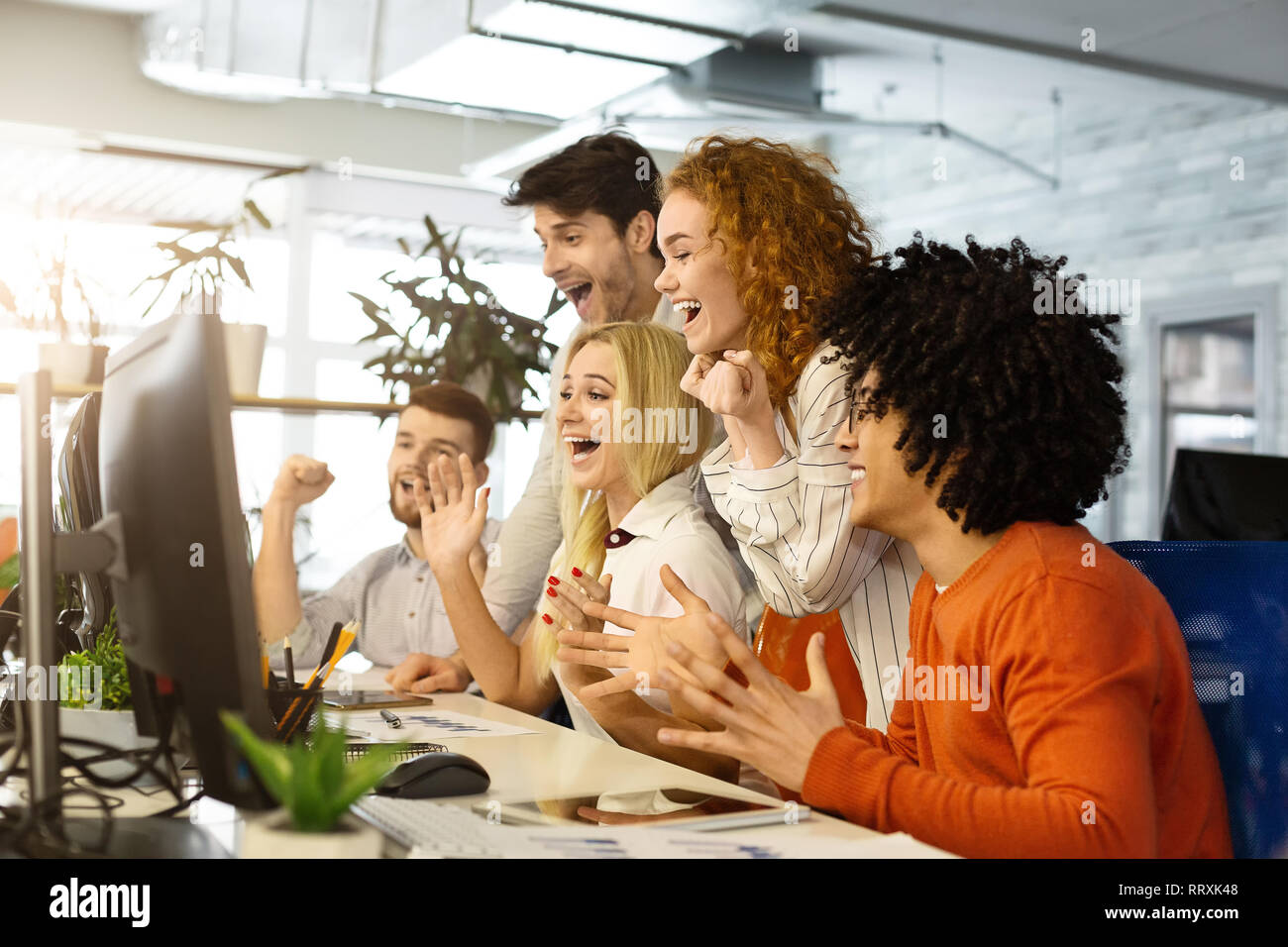 Business team looking at screen of computer celebrating victory Stock ...