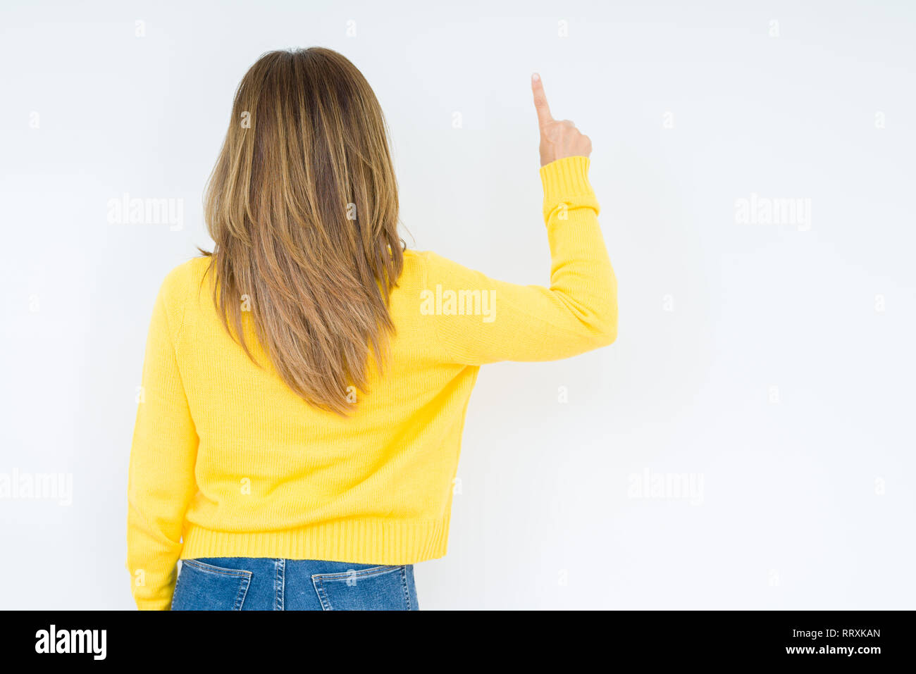 Beautiful middle age woman wearing yellow sweater over isolated ...