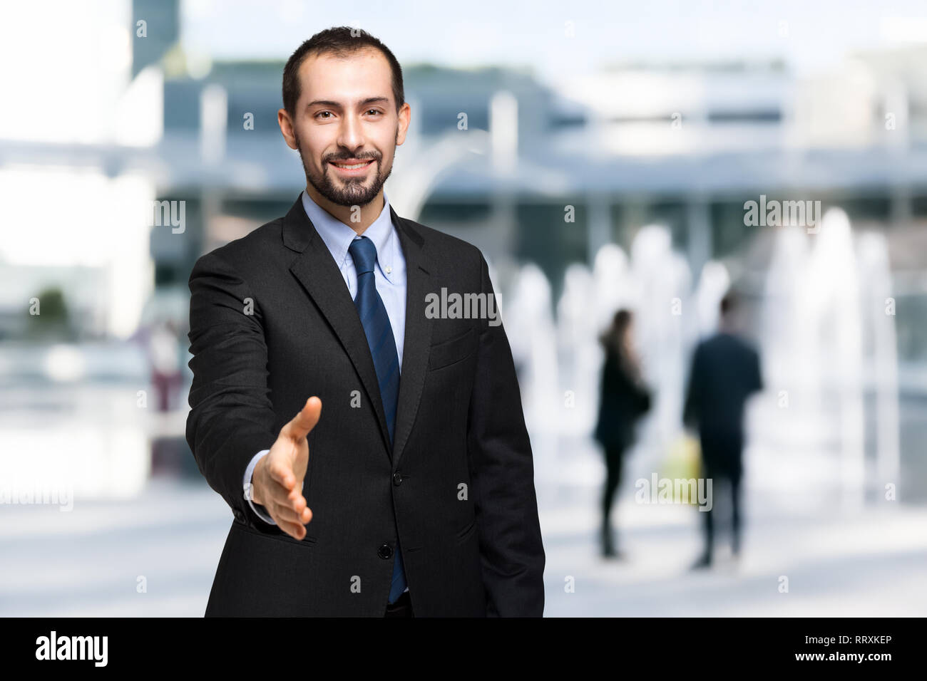 Handsome businessman offering handshake in an urban setting Stock Photo ...