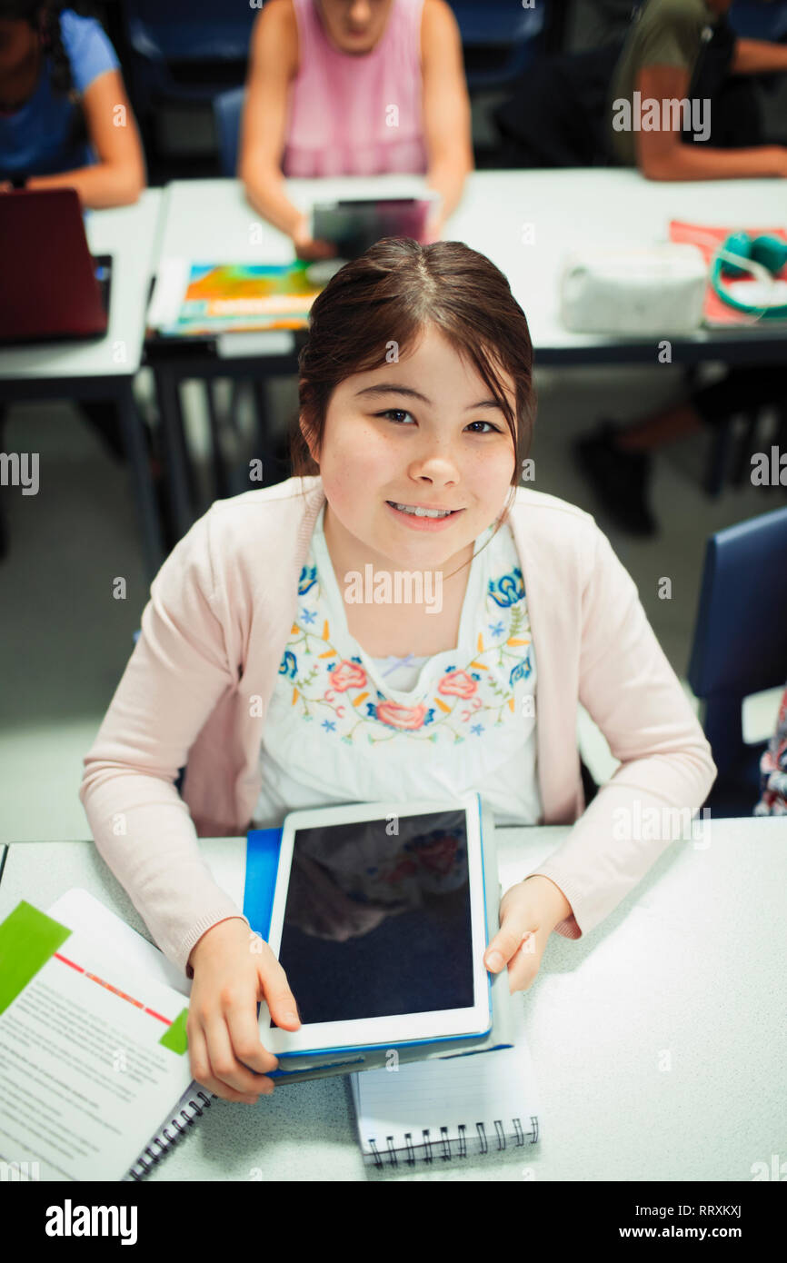 Portrait smiling, confident junior high school girl student using ...